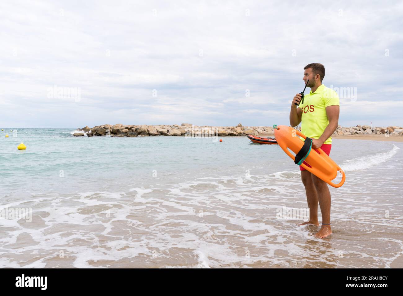 Photo with copy space of lifeguard standing on the edge of the sea ...