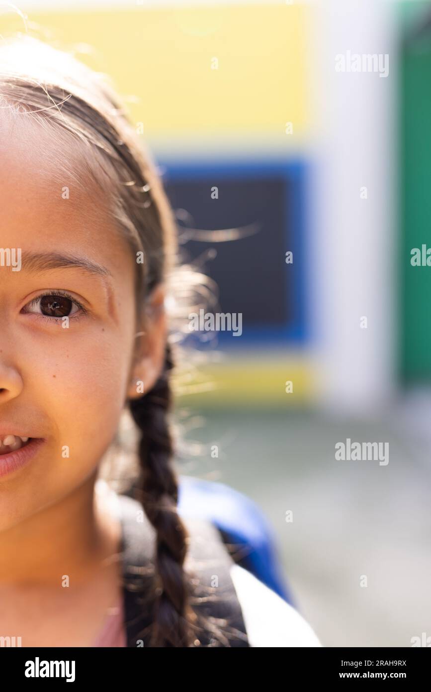 Vertical half face portrait of smiling cauasian elementary schoolgirl ...