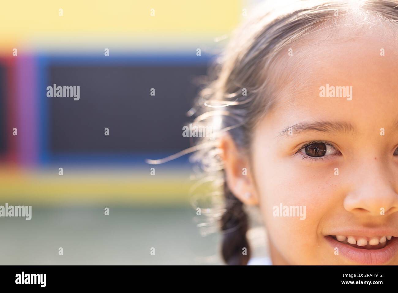 Half face portrait of smiling cauasian elementary schoolgirl in school ...
