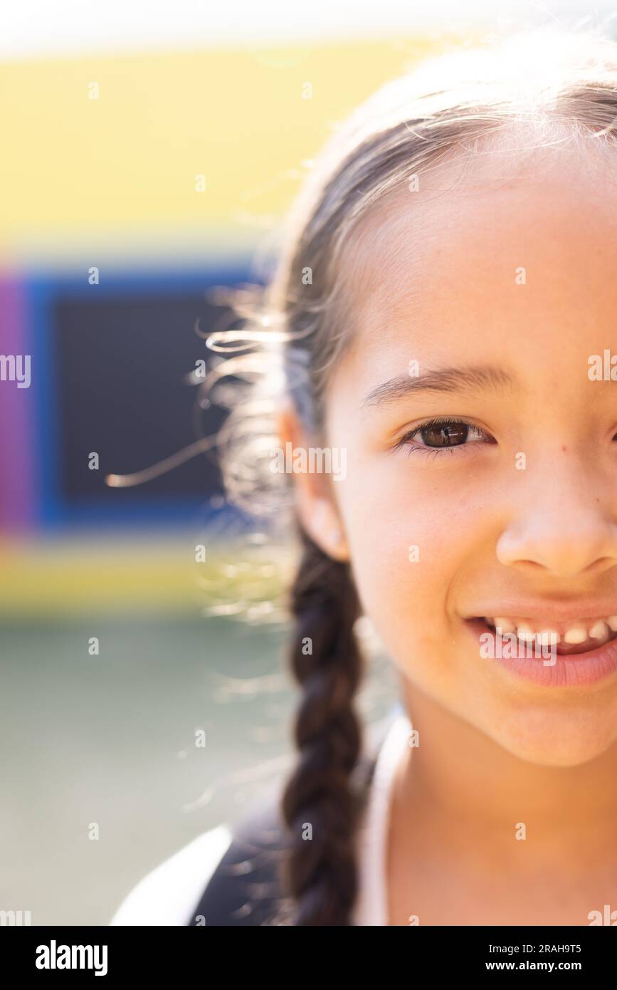 Vertical half face portrait of smiling cauasian elementary schoolgirl ...