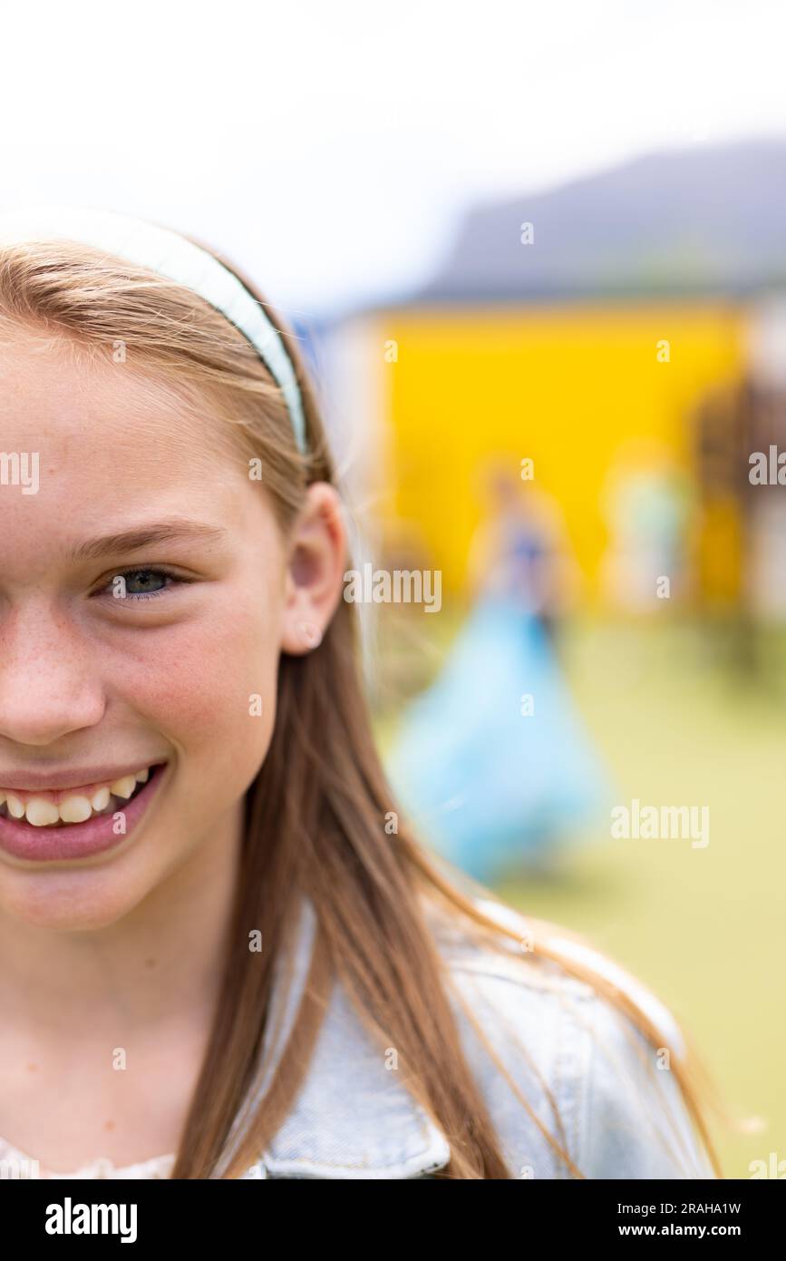 Vertical half face portrait of smiling caucasian schoolgirl in ...