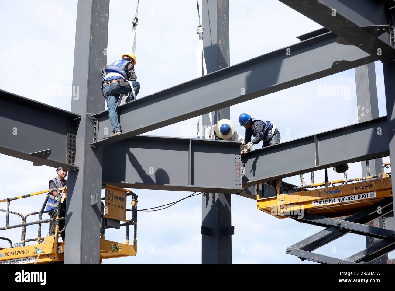 ZIXING, CHINA - JULY 3, 2023 - Workers install steel beams high in the ...