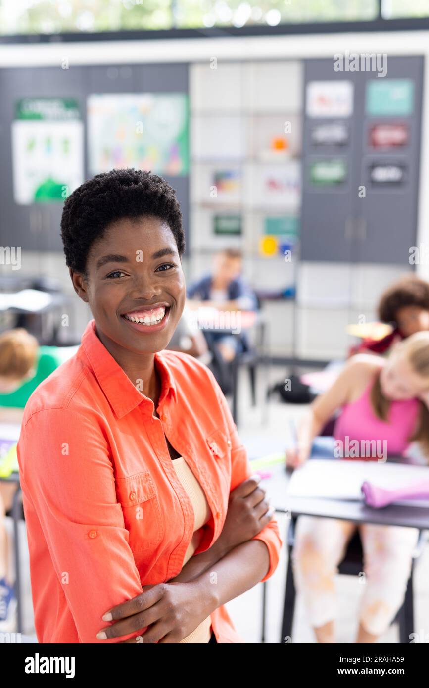Vertical portrait of happy african american female teacher in class ...
