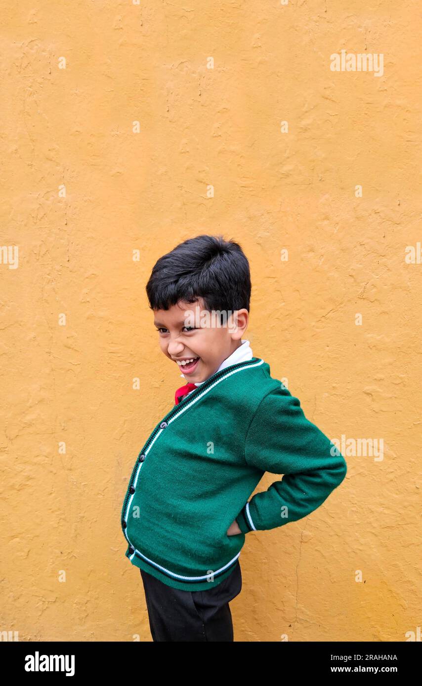 9-year-old dark-skinned Latino boy in school uniform suffers from back ...