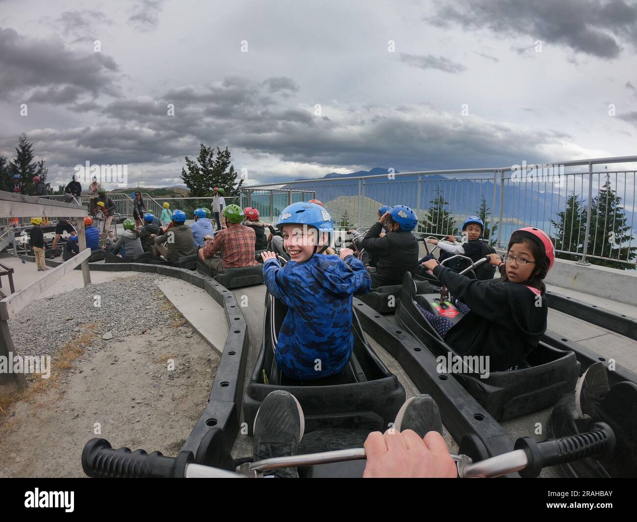 A teenage girl smiles with joy on the Skyline Luge popular tourist ...