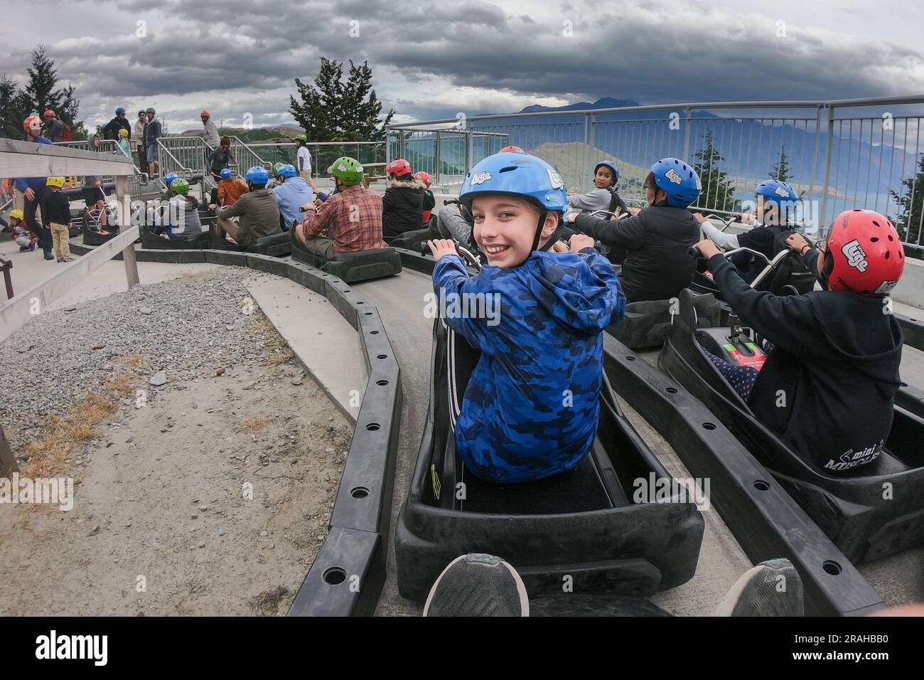 A teenage girl smiles with joy on the Skyline Luge popular tourist ...