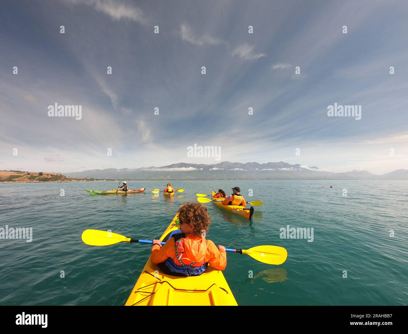 A family enjoys a dramatic open sea kayak trip along the coastline of ...