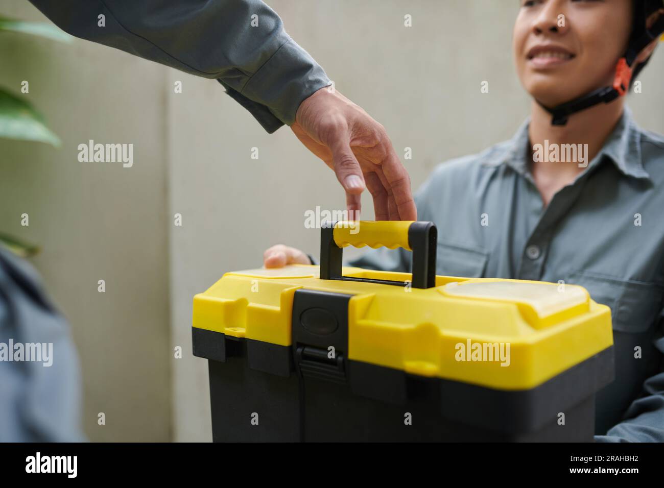 Worker giving big toolbox to solar panel installer Stock Photo - Alamy