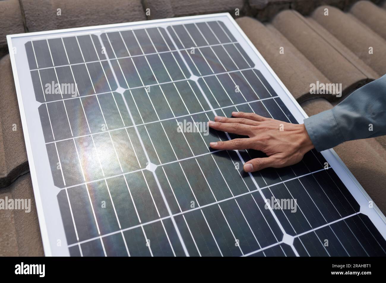 Hand of contractor touching solar panel on roof, alternative energy ...