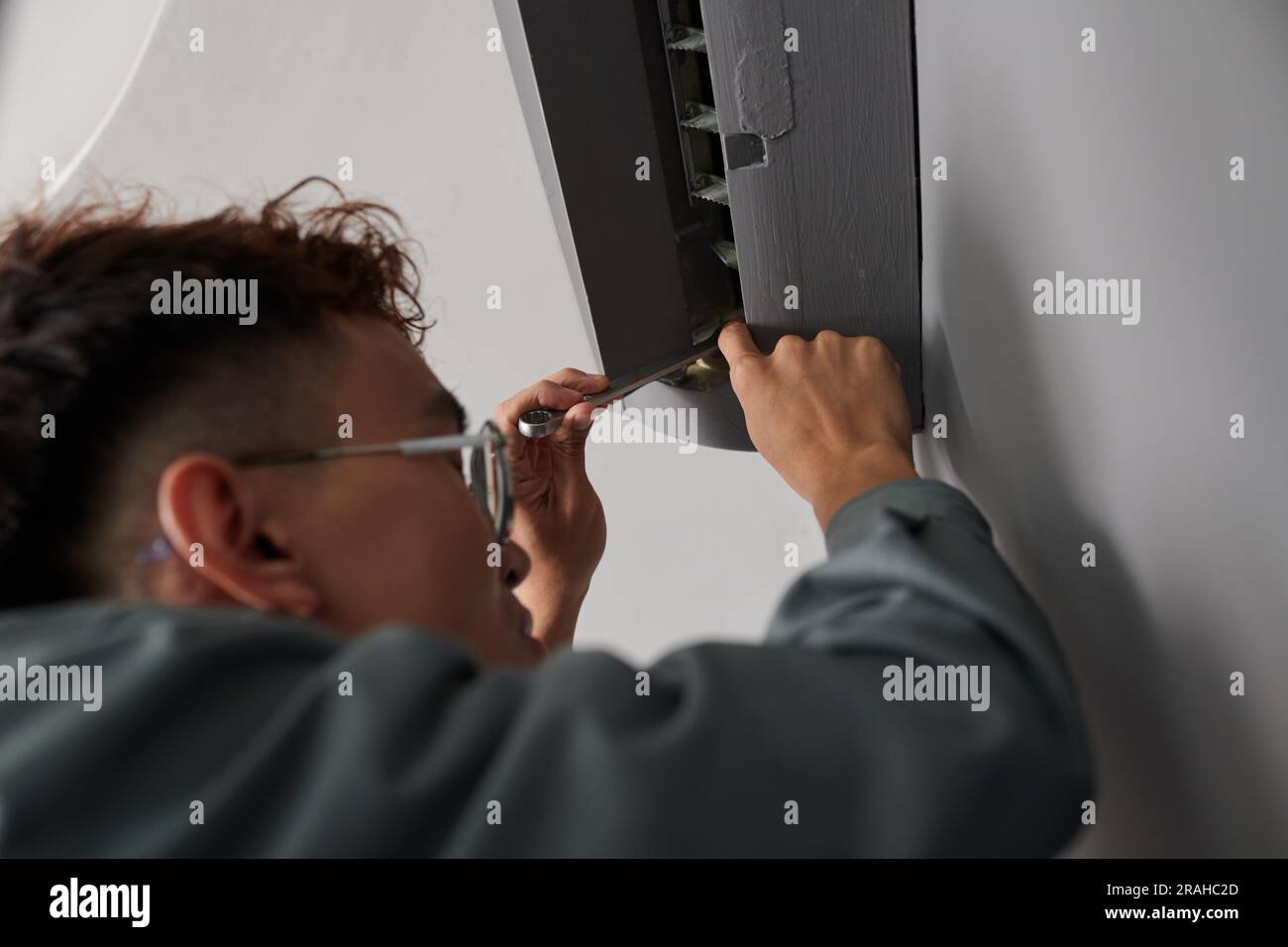 Technician fixing broken air conditioner in residential building Stock ...
