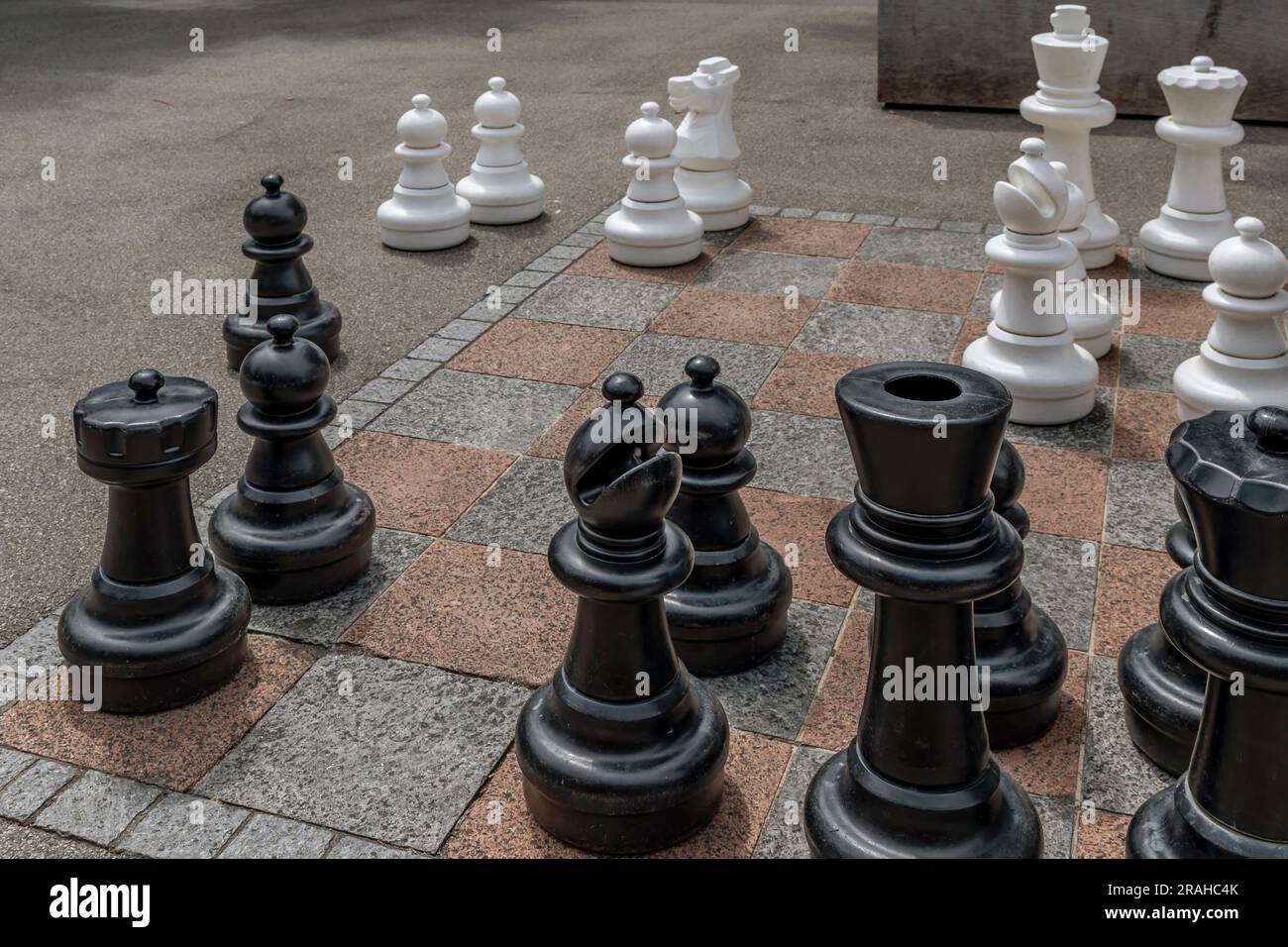 A chess board with large pieces is positioned on the lakefront of ...