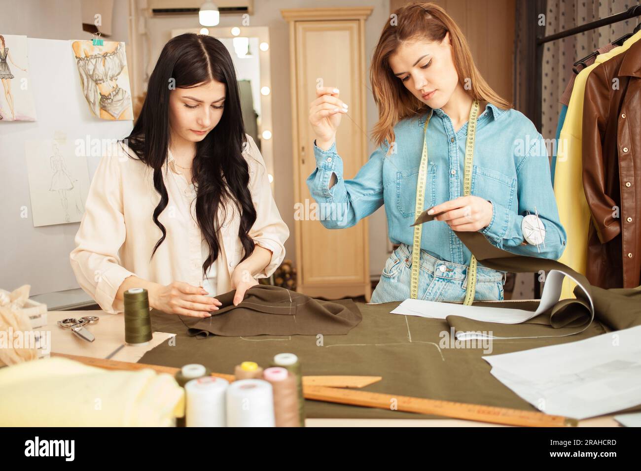 Seamstresses sew fabric by hand, sweep away details of future outfit ...