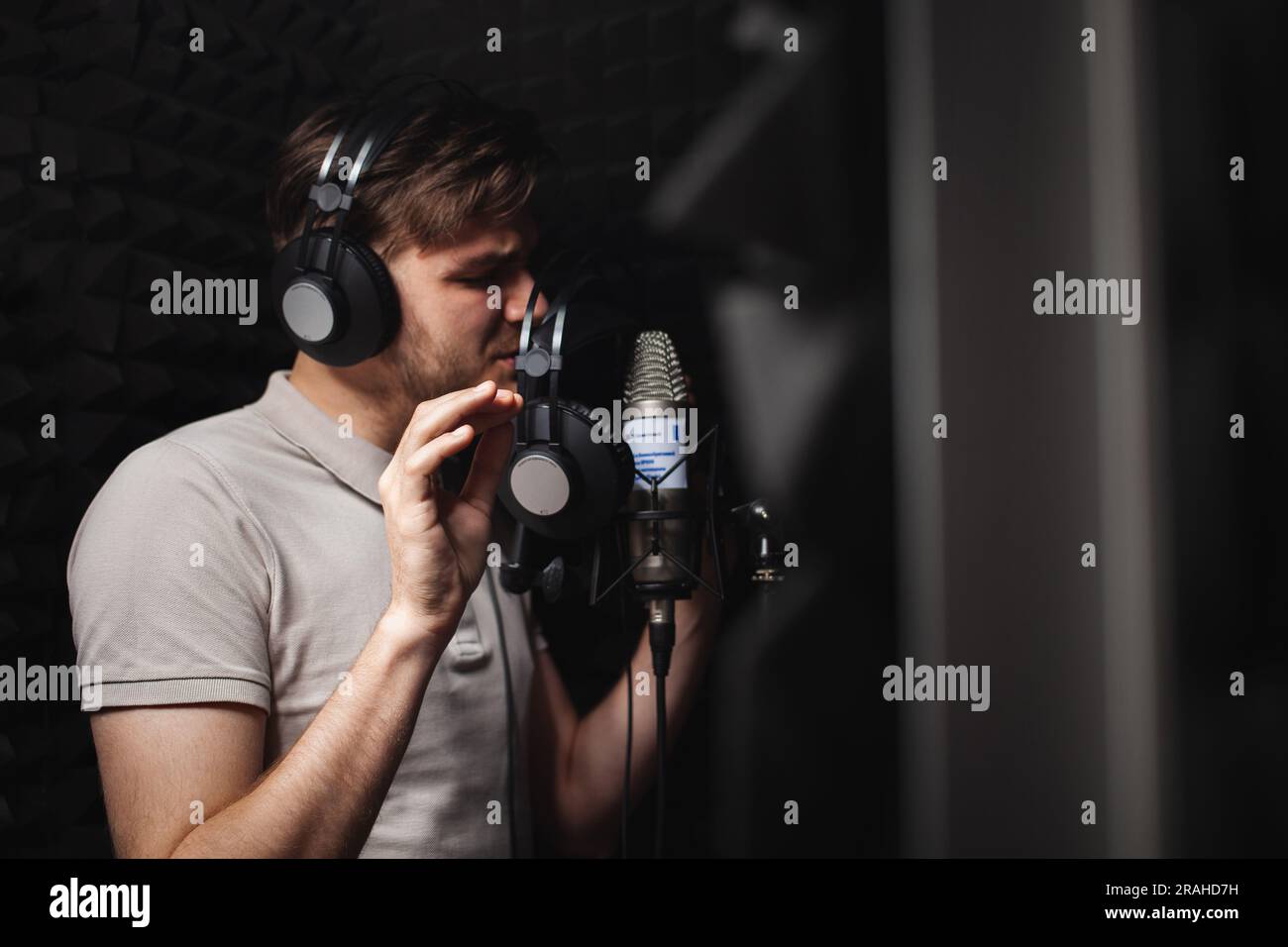 man sings into microphone, professional recording studio, headphones ...