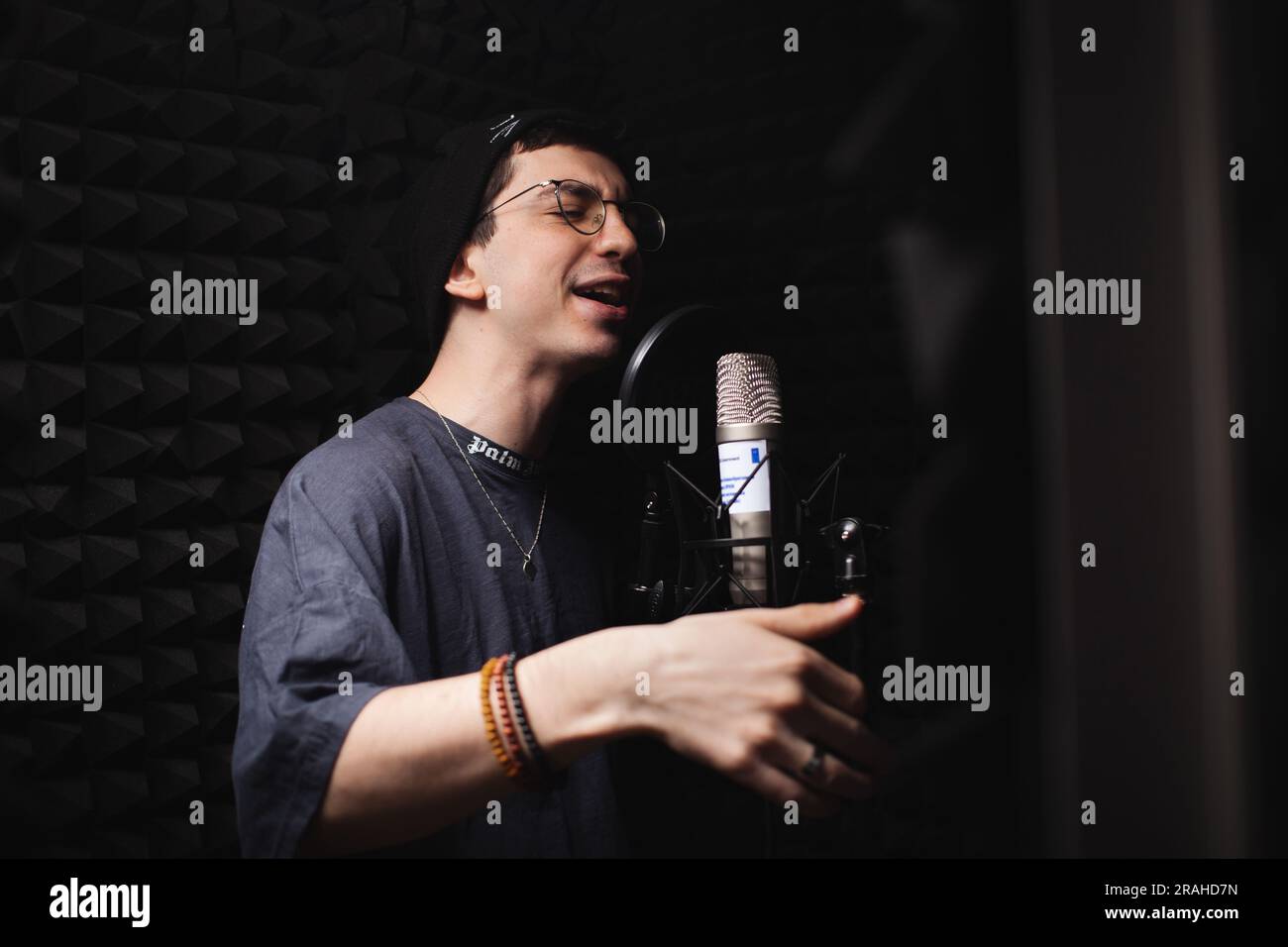 man sings into microphone, professional recording studio, headphones ...