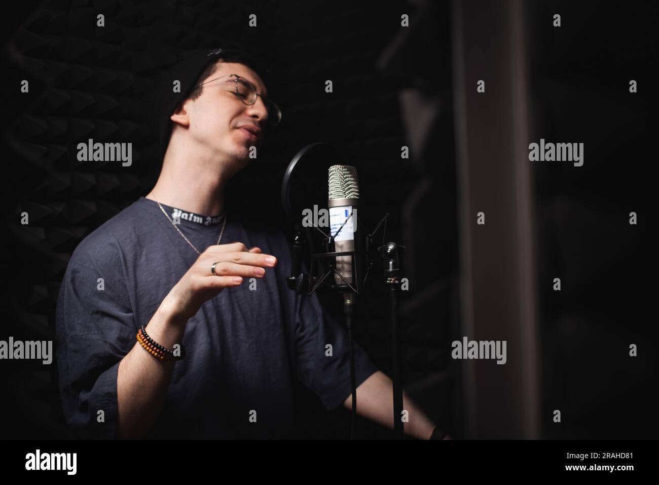 man sings into microphone, professional recording studio, headphones ...