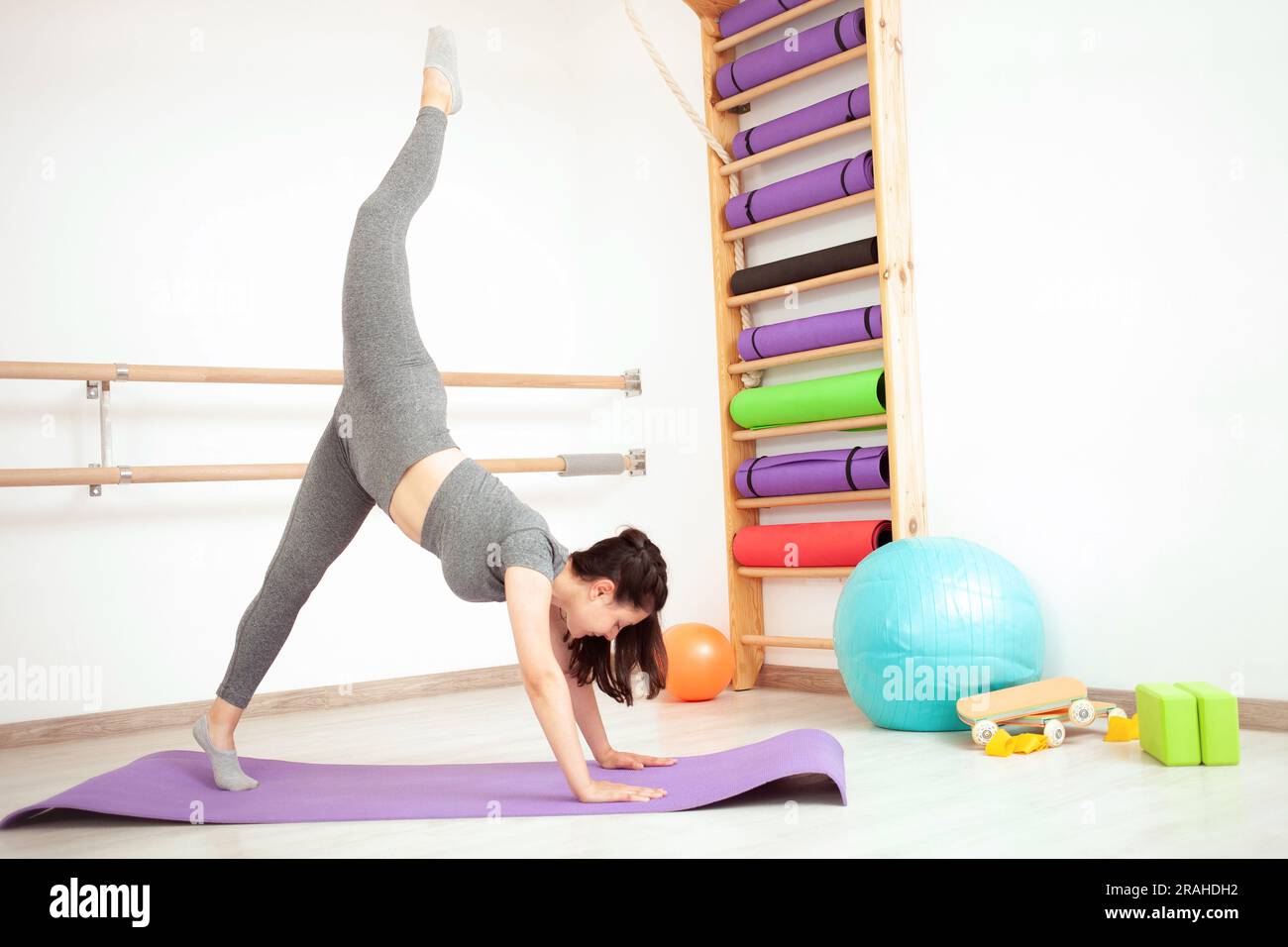 woman makes bridge with vertical twine legs, gymnast in gym Stock Photo ...