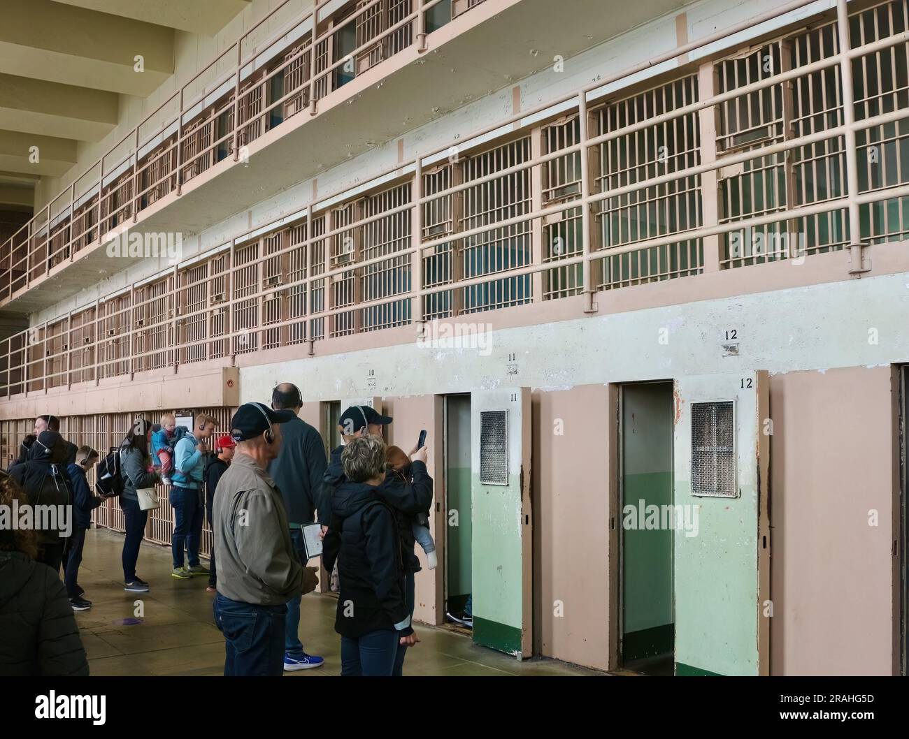 Tourists inside Alcatraz Federal penitentiary looking at corridors with ...