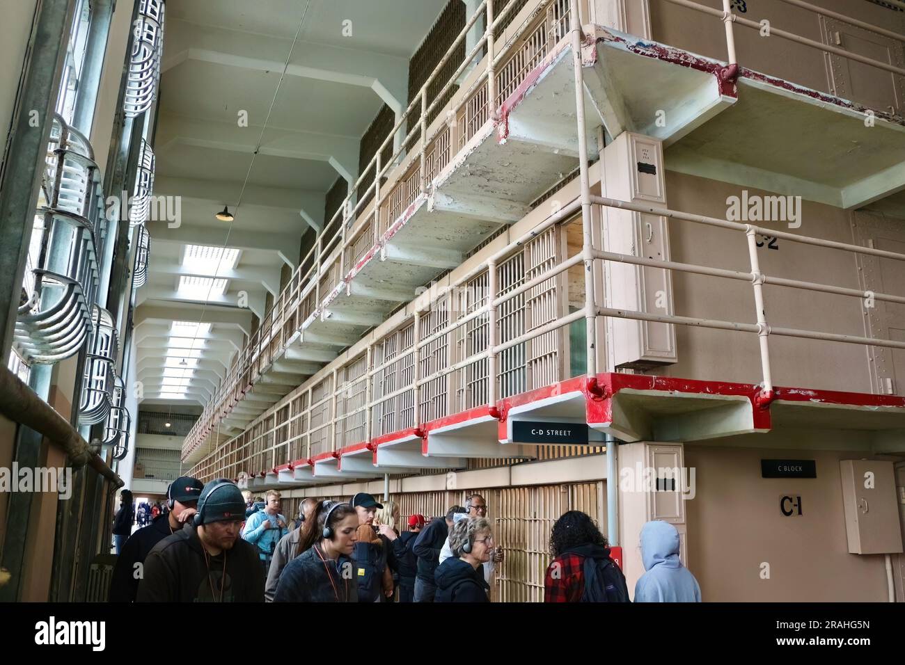 Tourists inside Alcatraz Federal penitentiary looking up at corridors ...
