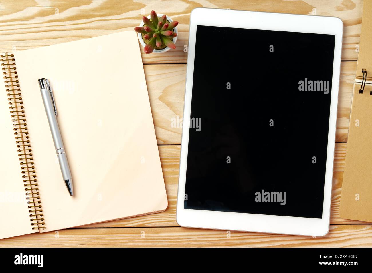 Top view of wooden table with white digital tablet with black screen on ...