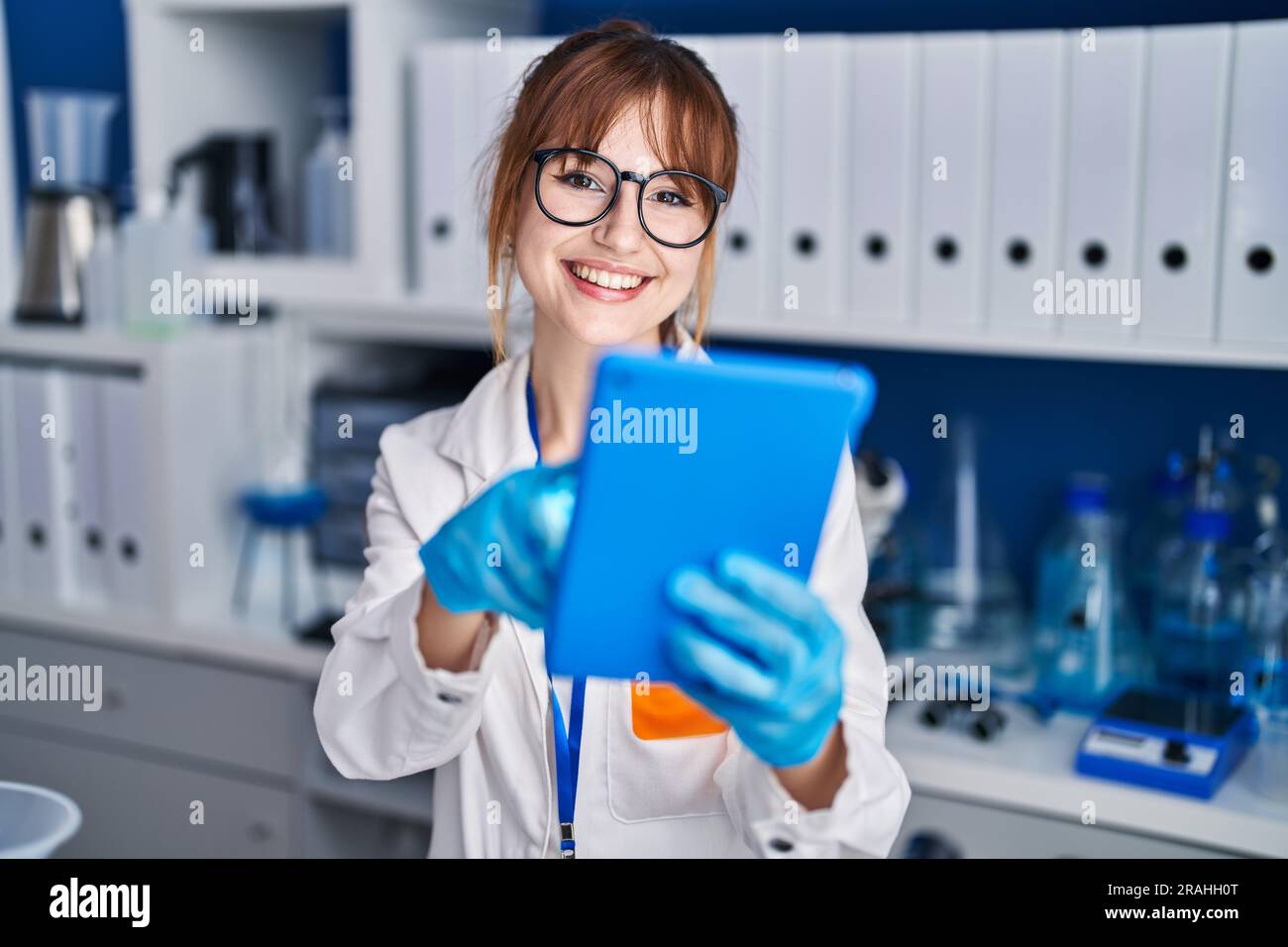Young woman scientist smiling confident using touchpad at laboratory Stock Photo - Alamy