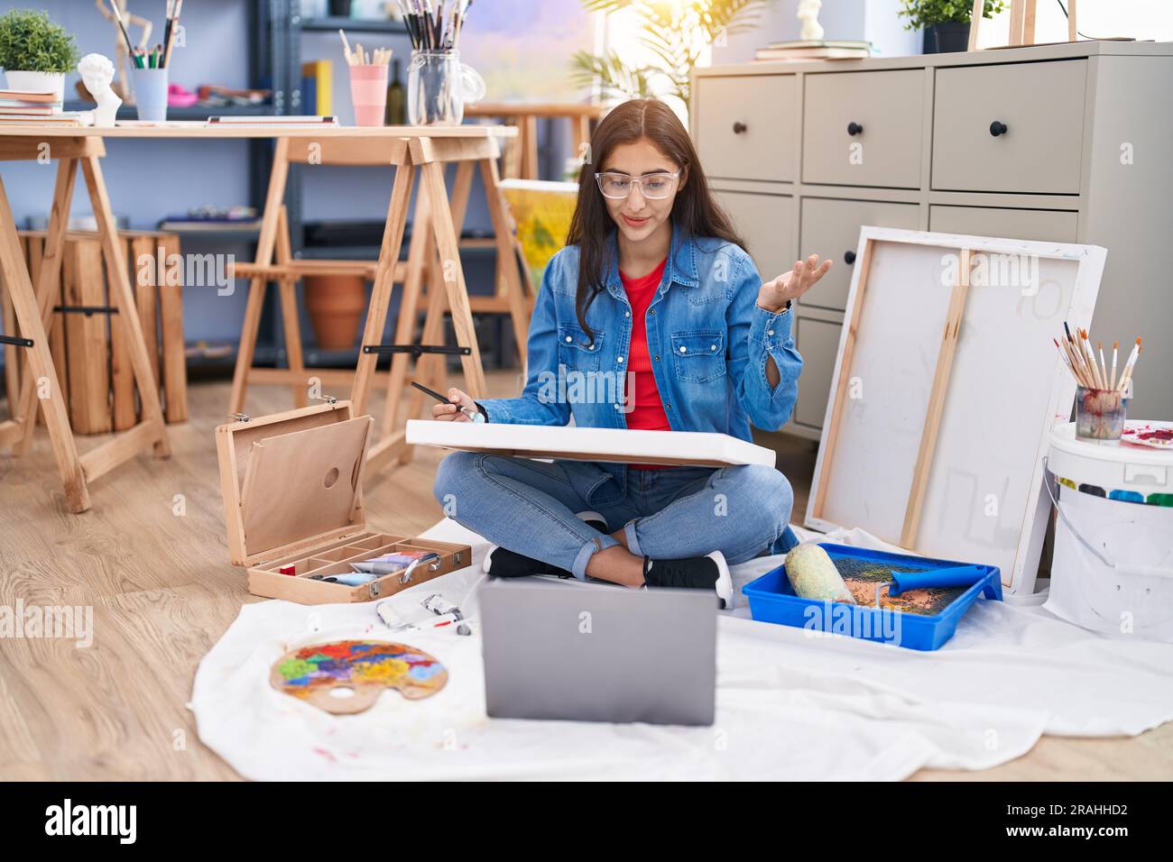 Young hispanic girl artist having video call drawing at art studio ...