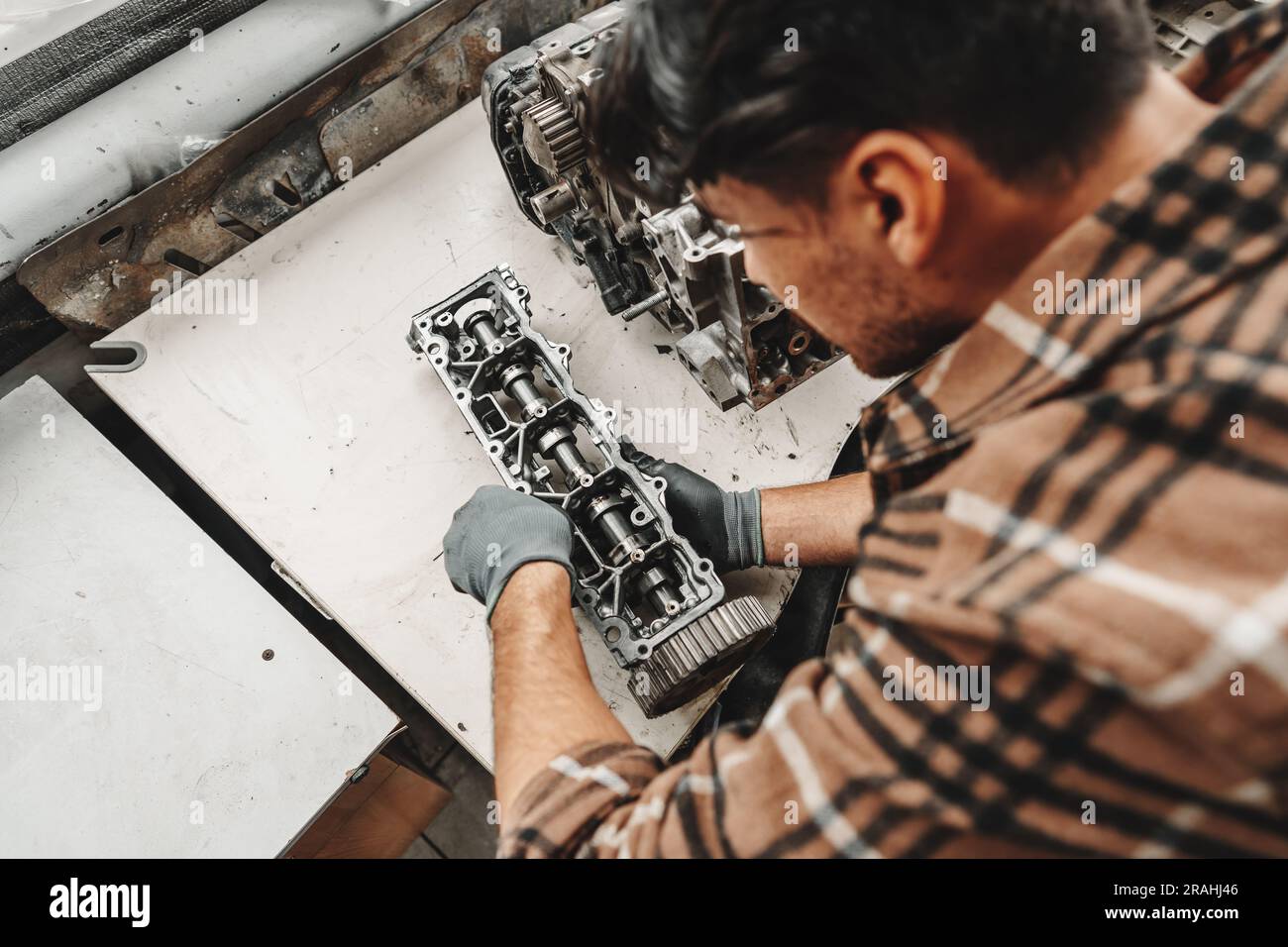 Workman disassembling car engine at the working table of the car ...