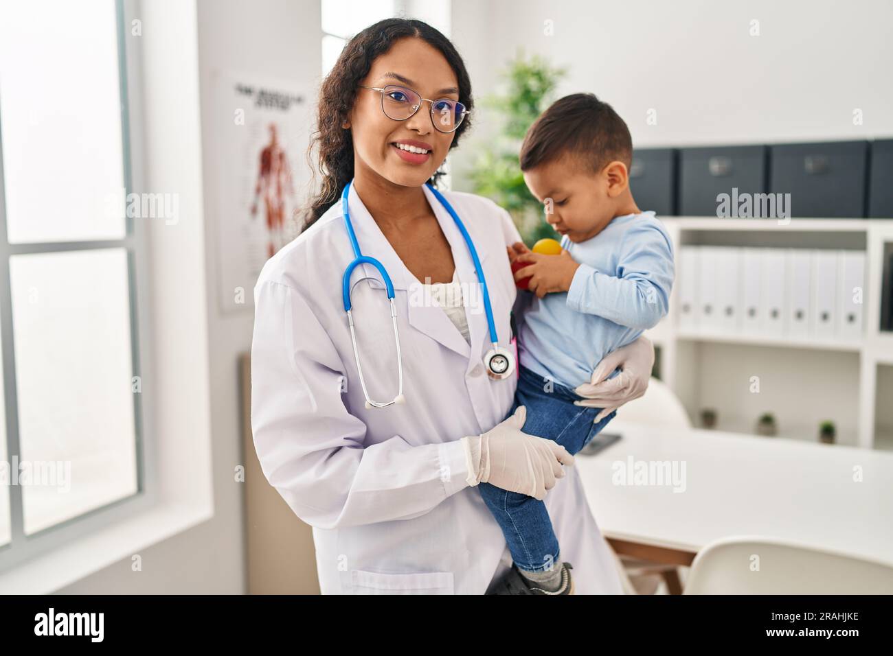 Mother and son pediatrician and patient hugging each other at clinic ...