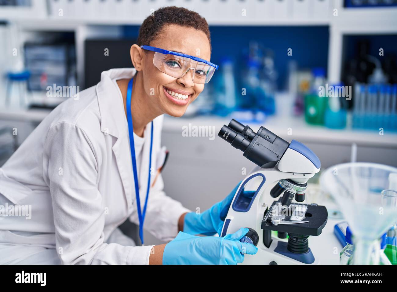 African american woman scientist using microscope at laboratory Stock Photo - Alamy
