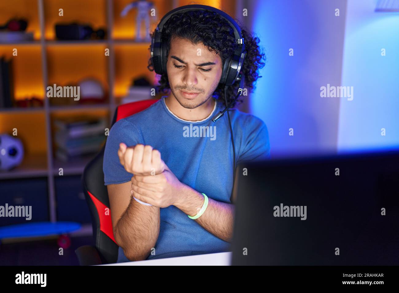 Young latin man streamer stressed suffering for wrist pain at gaming ...