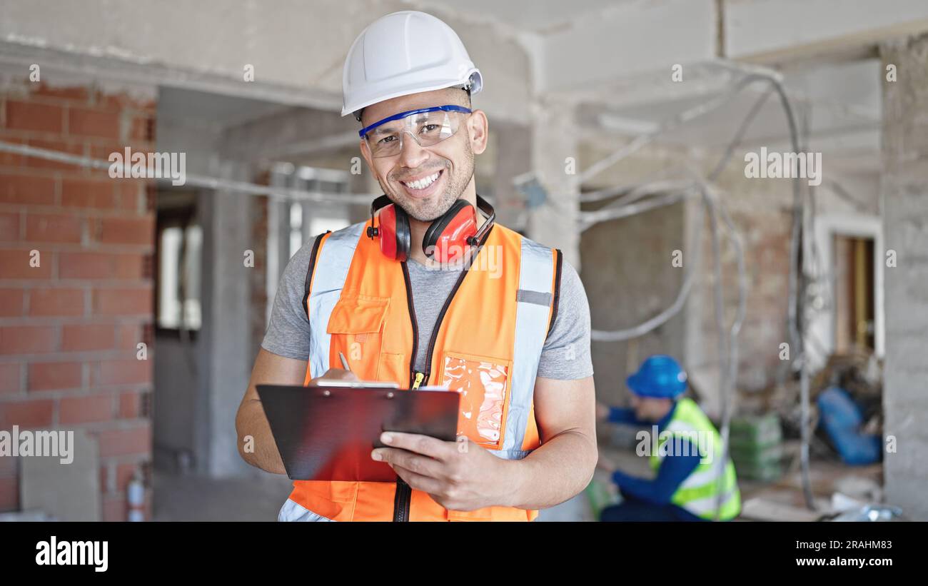Two men builders writing document working at construction site Stock ...