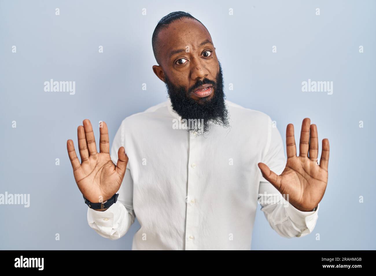 African american man standing over blue background moving away hands ...