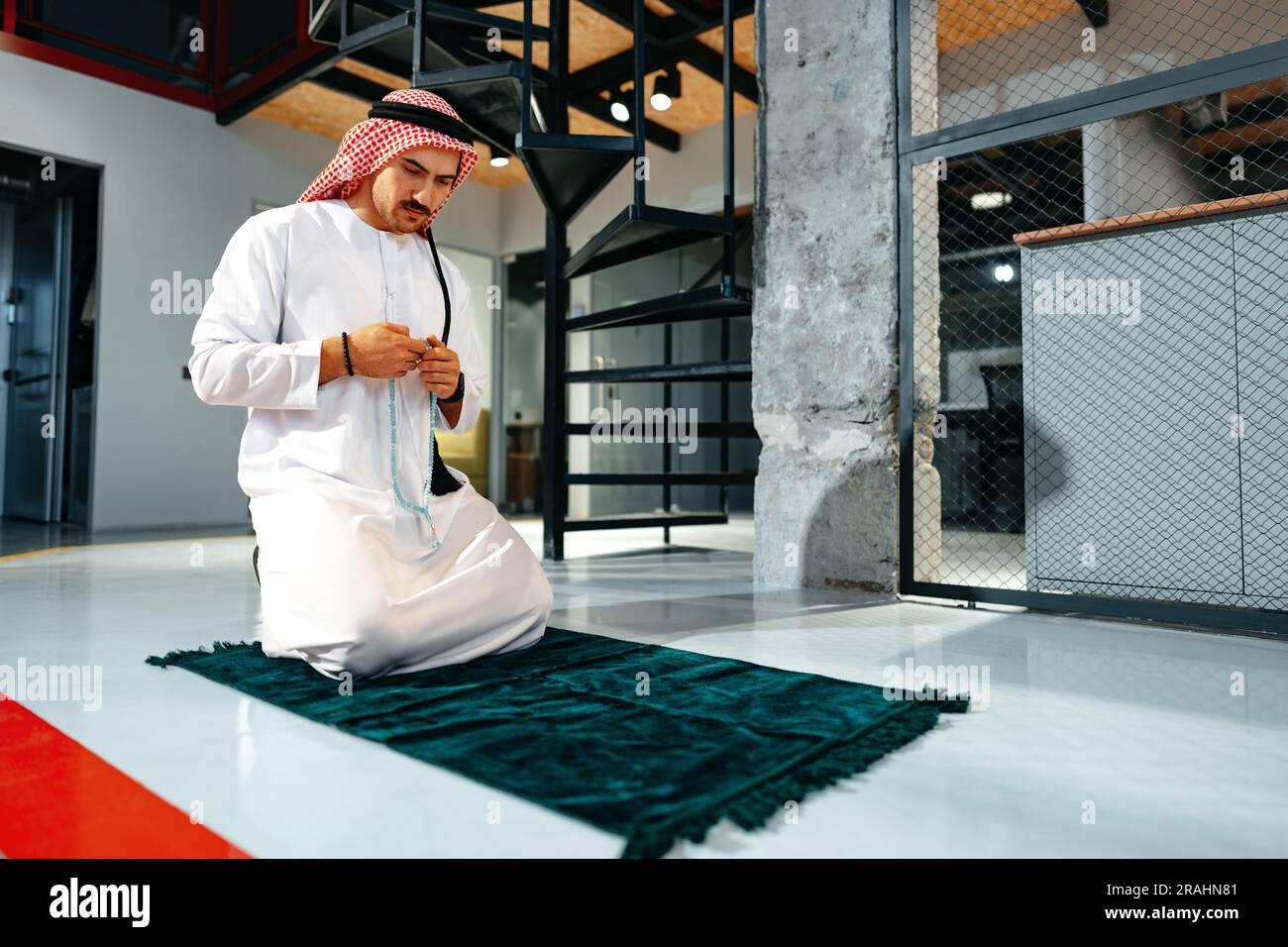 Young arab muslim man praying in office on carpet Stock Photo - Alamy