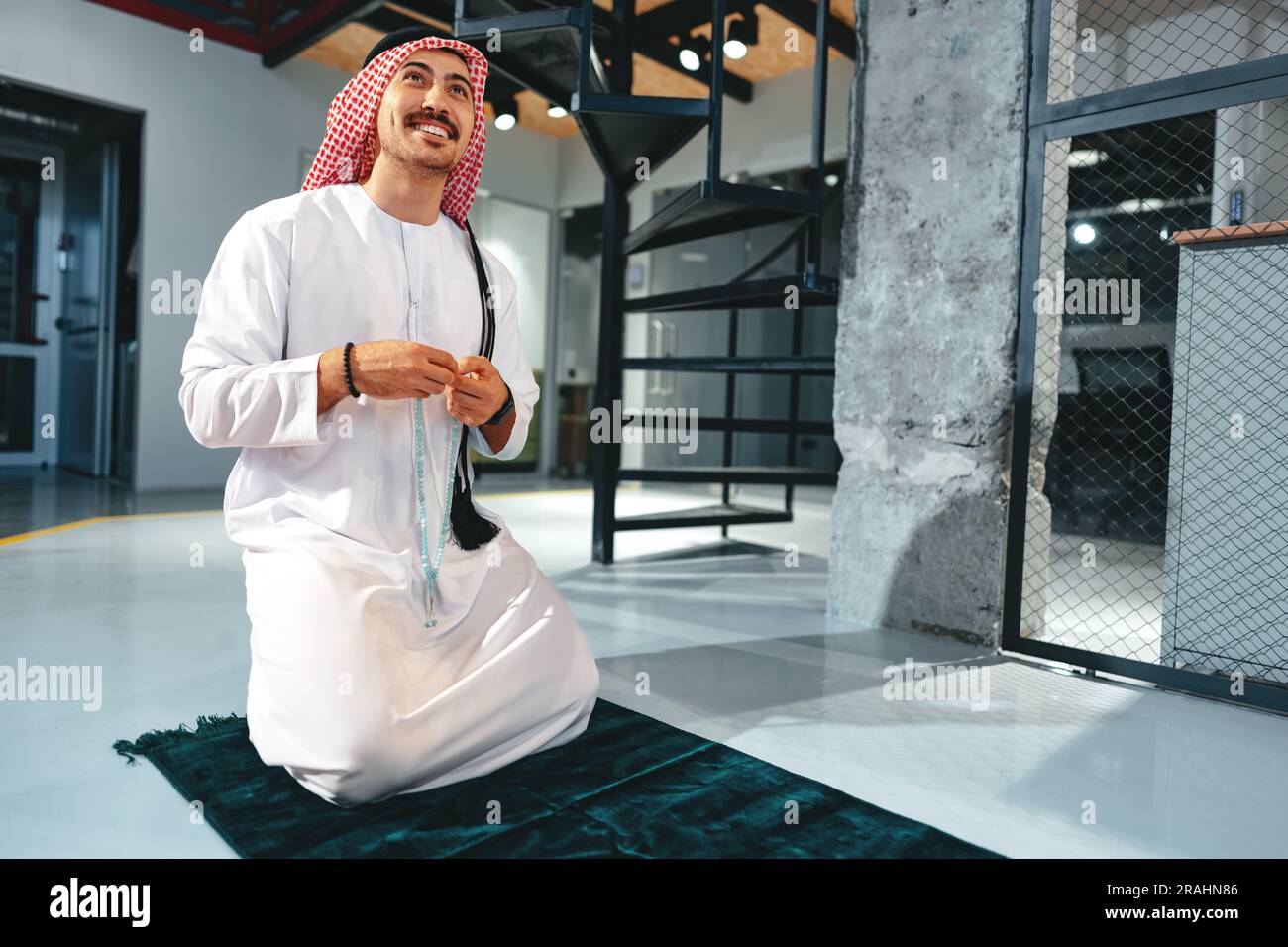 Young arab muslim man praying in office on carpet Stock Photo - Alamy