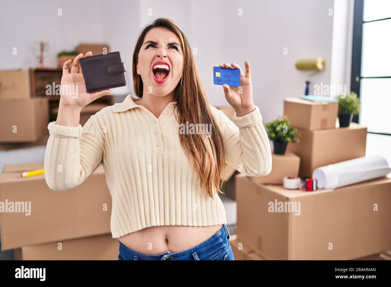 Young hispanic woman moving to a new home holding wallet and credit ...
