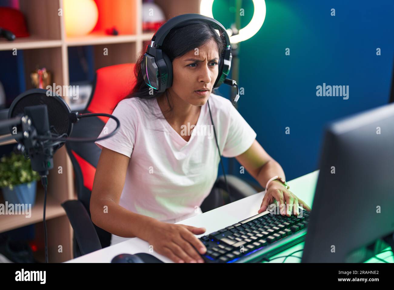 Young beautiful hispanic woman streamer playing video game using ...