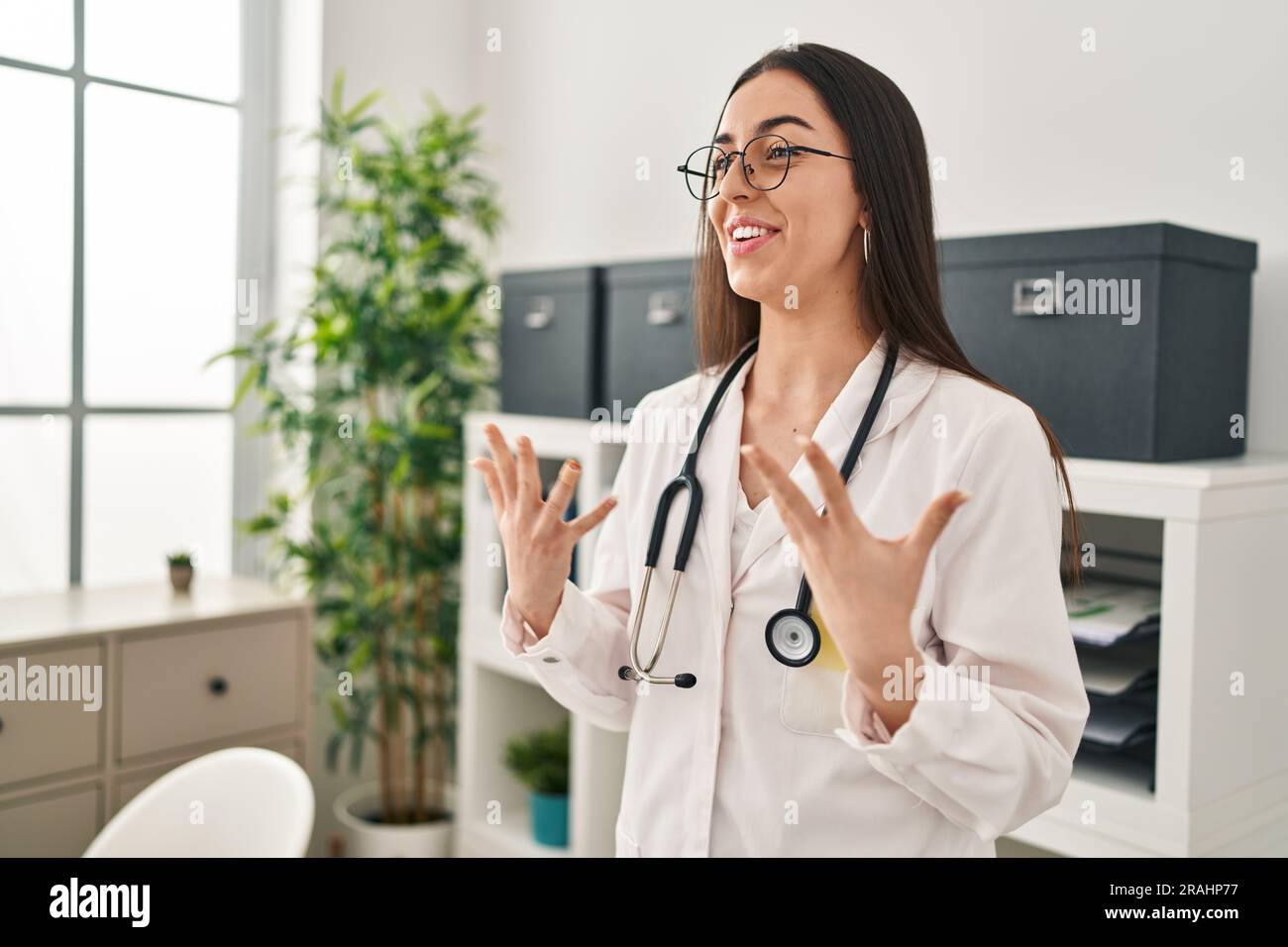 Young beautiful hispanic woman doctor smiling confident speaking at ...