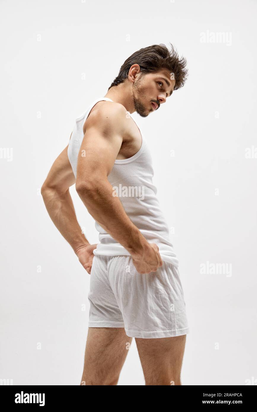 Young handsome Caucasian man wearing homewear posing over white studio ...