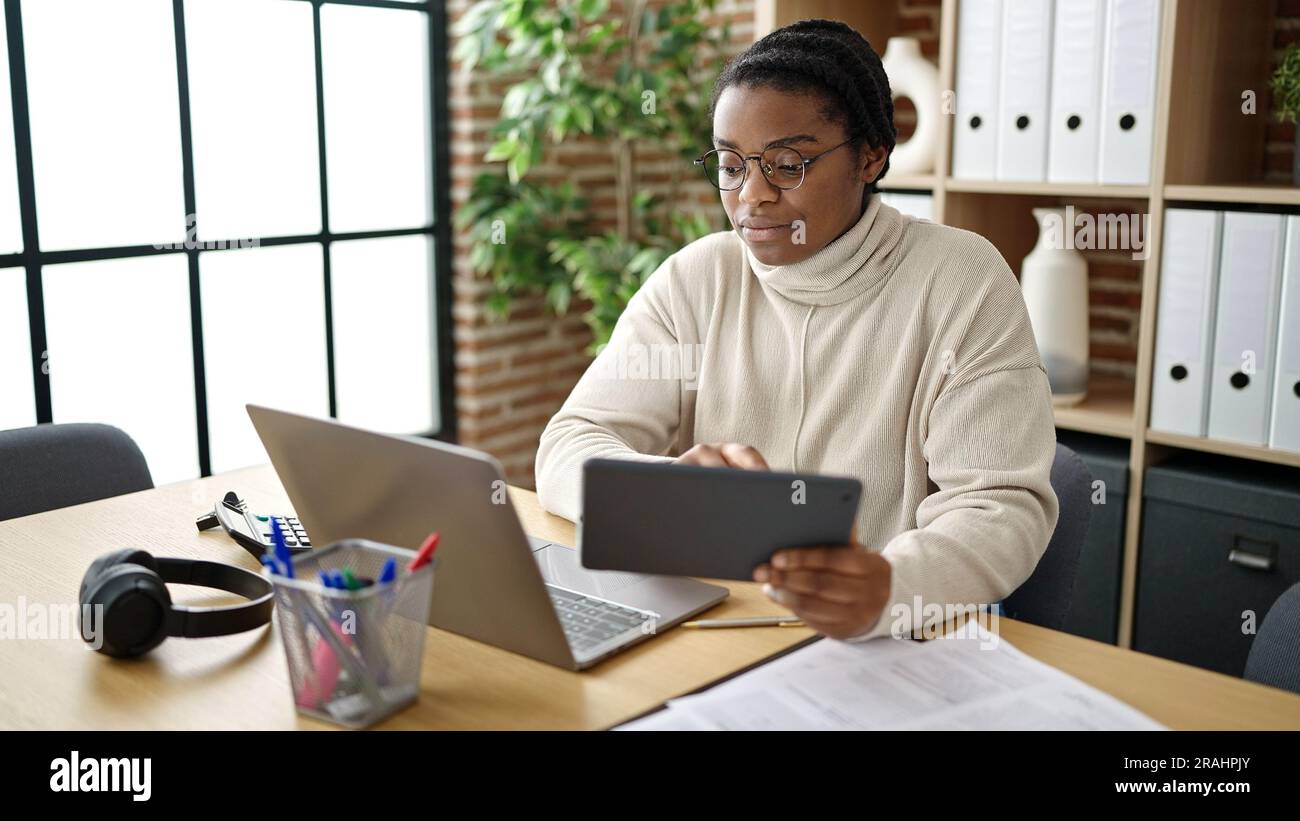 African american woman business worker using touchpad and laptop at ...