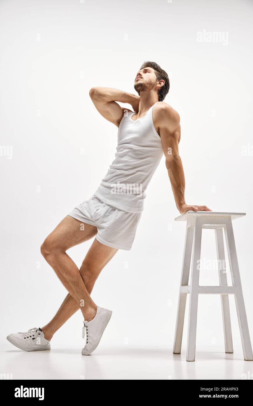 Young handsome Caucasian man wearing homewear posing over white studio ...