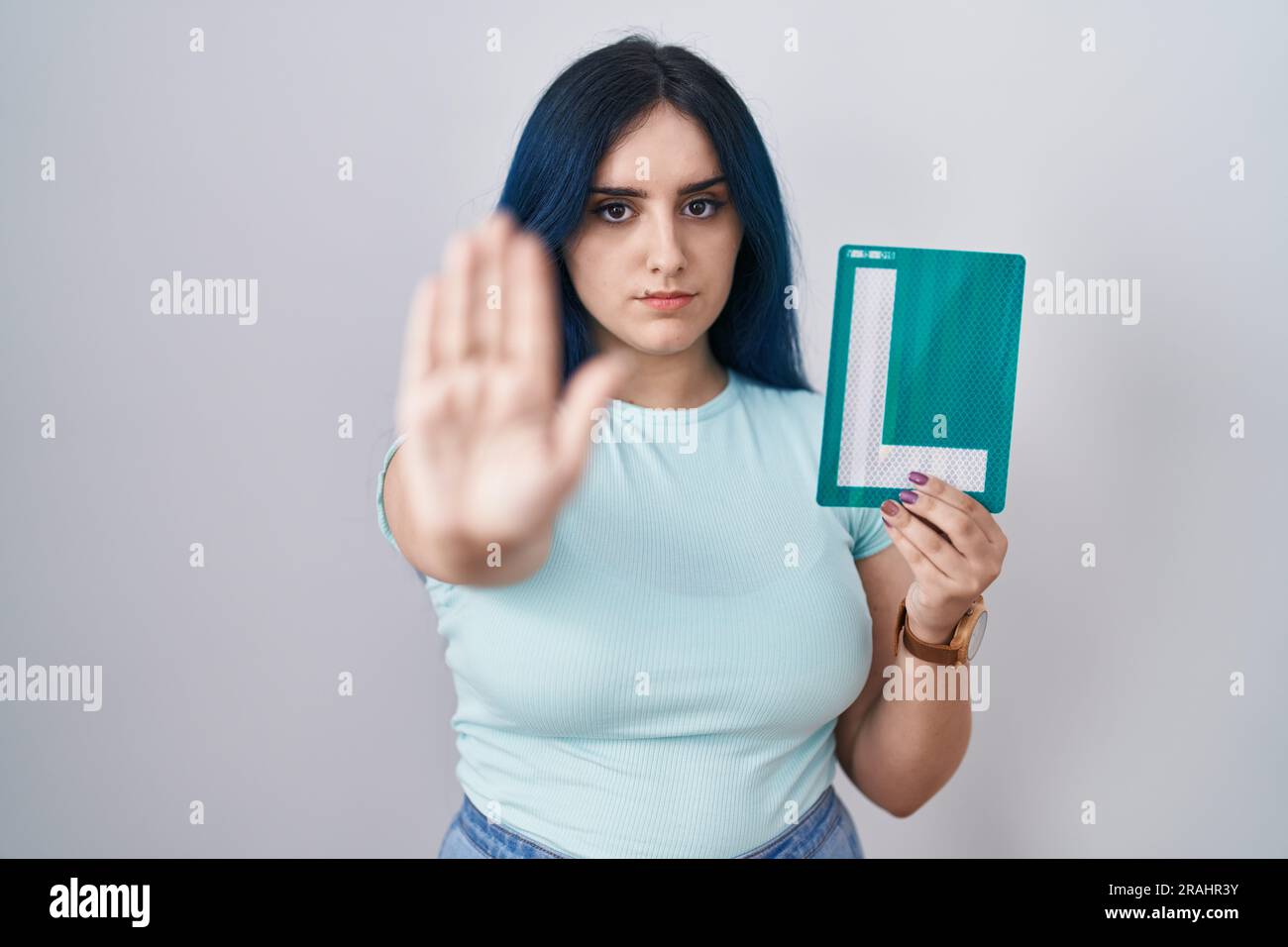 Young modern girl with blue hair holding l sign for new driver with ...