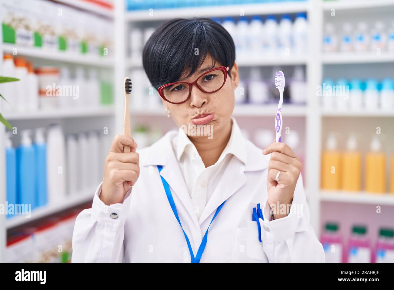 Young asian woman with short hair doing toothbrush comparative at ...