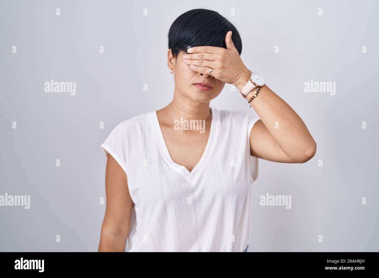 Young asian woman with short hair standing over isolated background ...