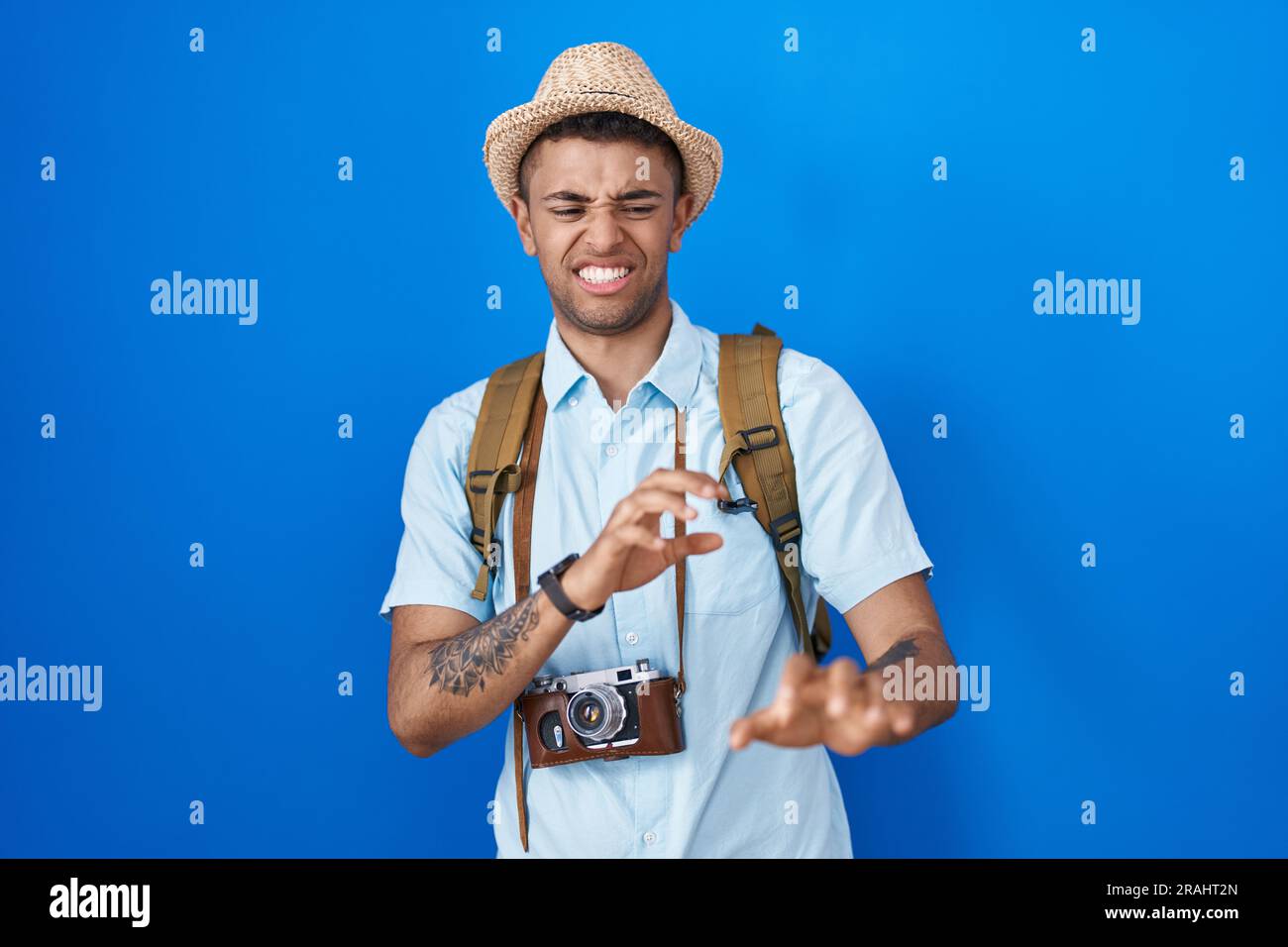 Brazilian young man holding vintage camera disgusted expression ...