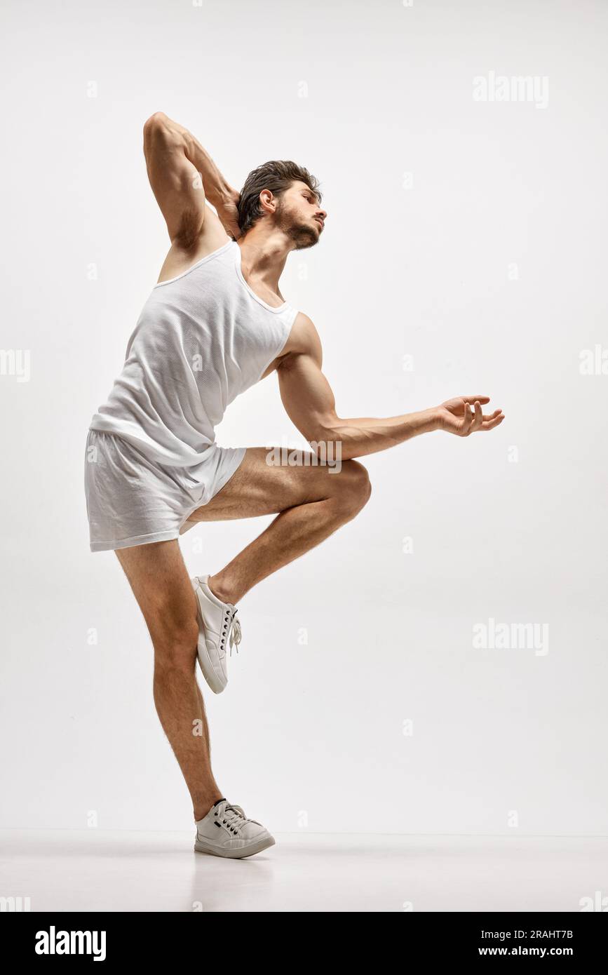 Young handsome Caucasian man wearing homewear posing over white studio ...