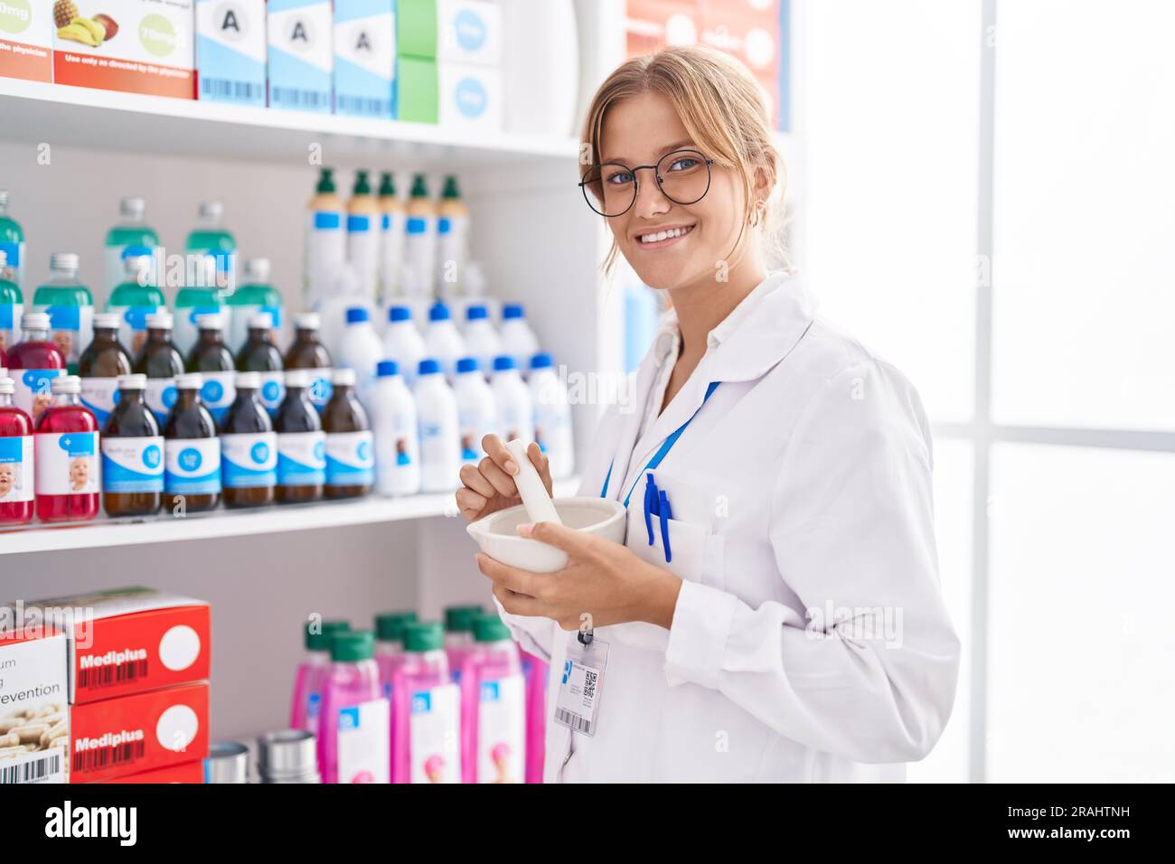 Young blonde girl pharmacist smiling confident working at pharmacy ...