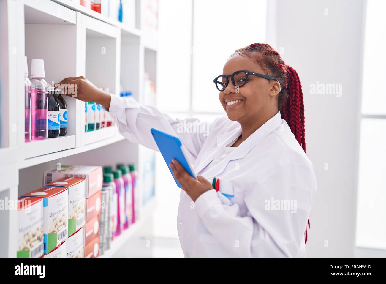African american woman pharmacist using touchpad working at pharmacy ...
