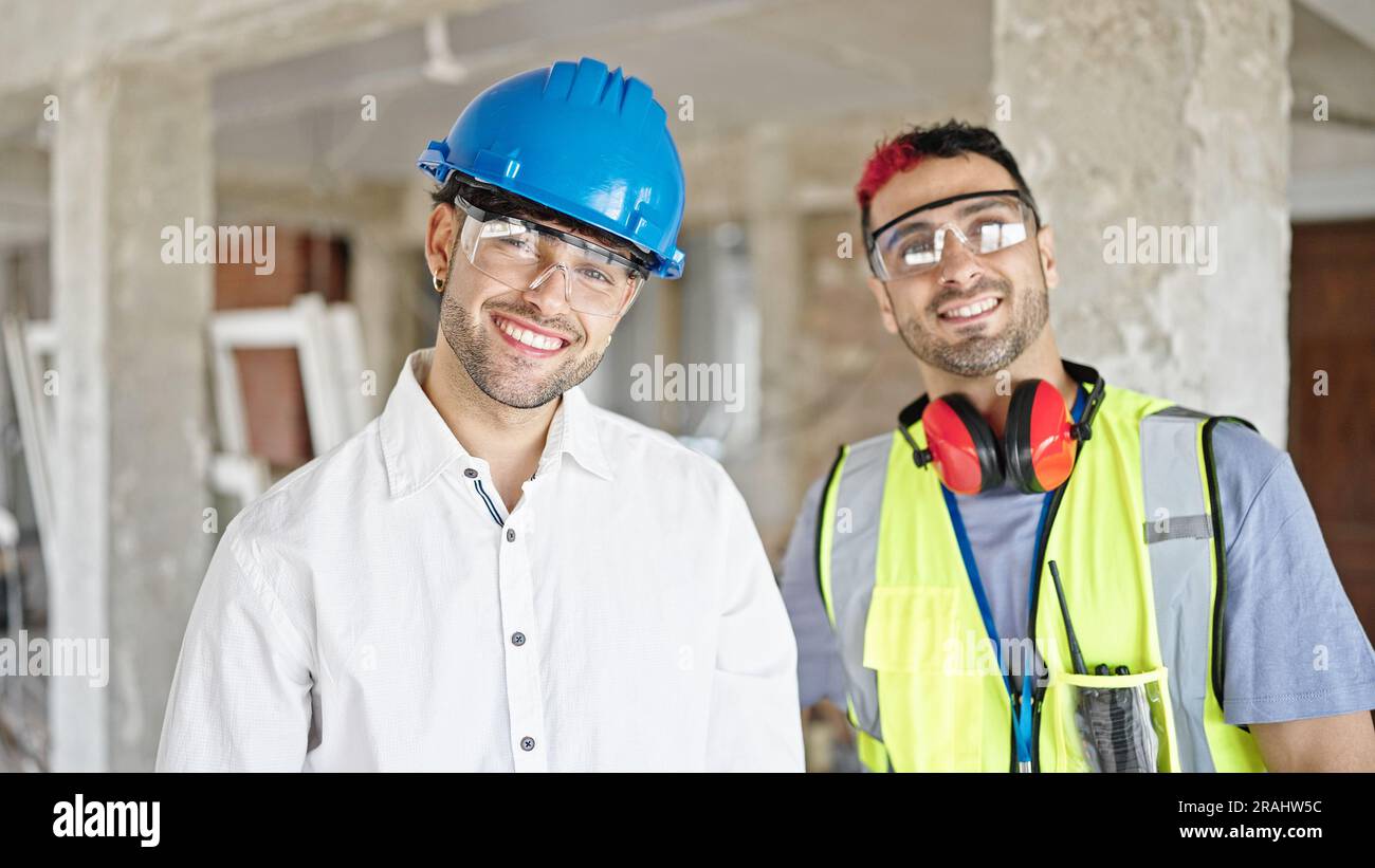 Two men builder and architect smiling confident standing together at ...