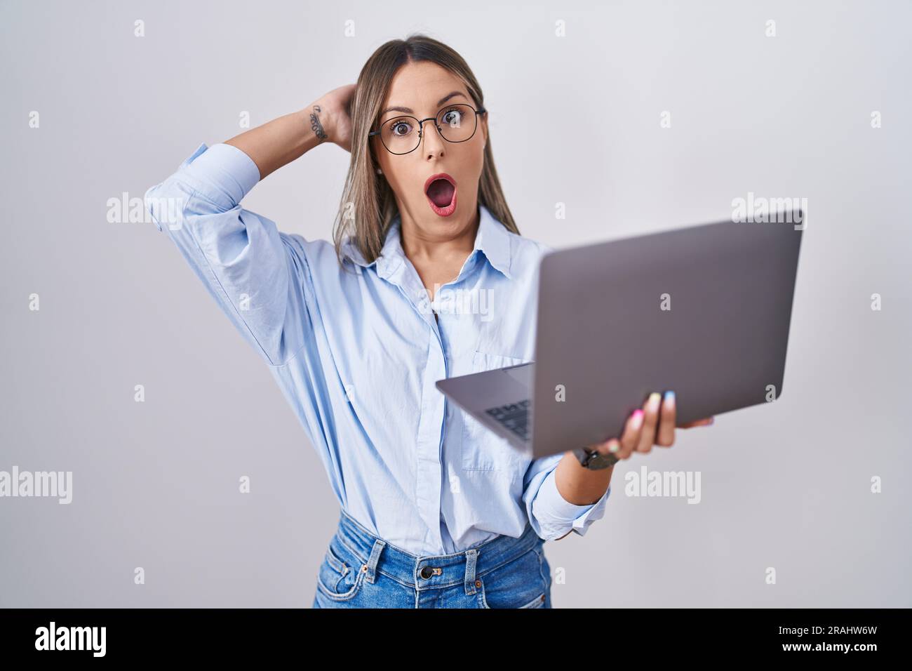 Young woman working using computer laptop crazy and scared with hands ...