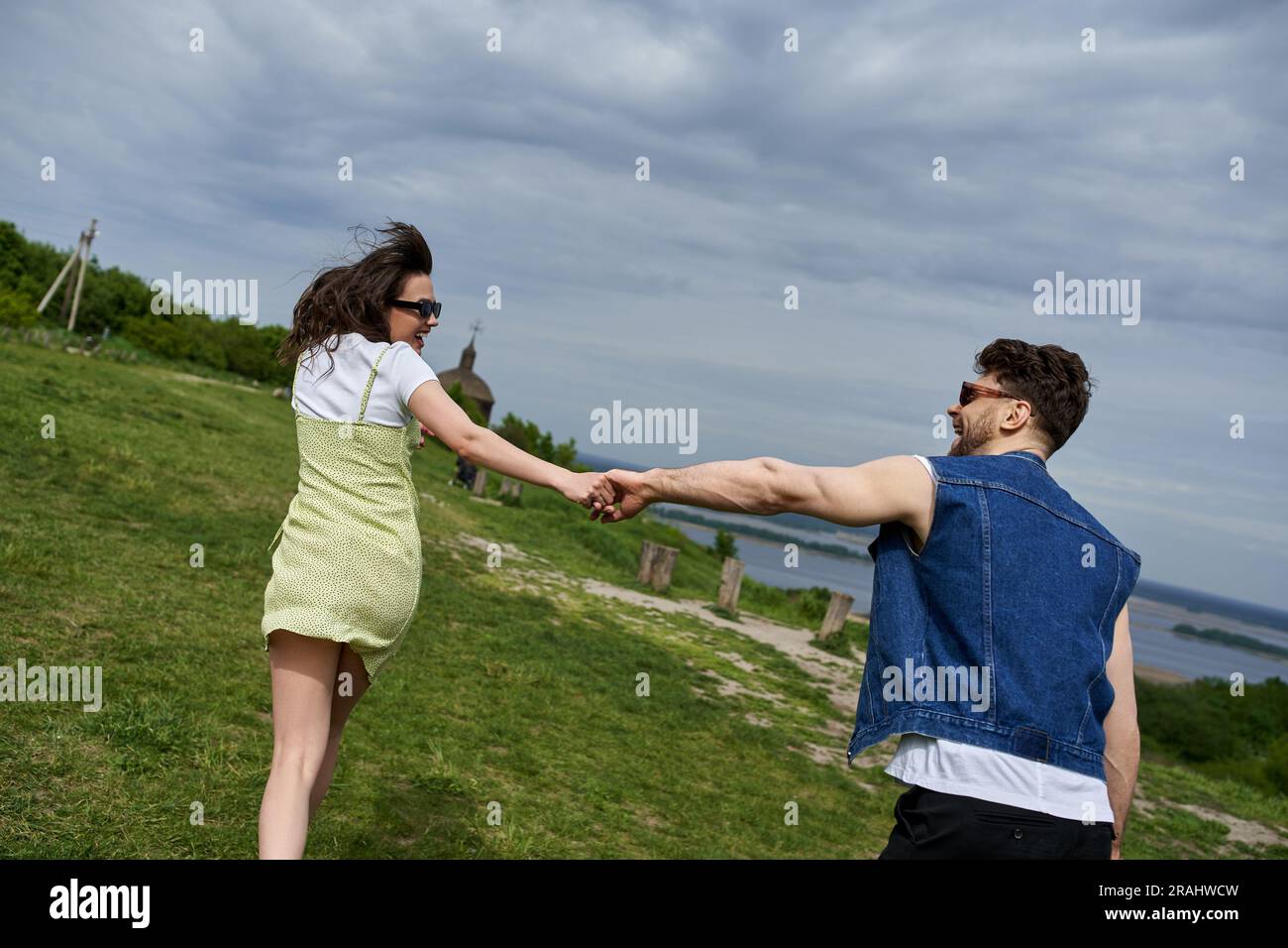 Side view of positive romantic couple in sunglasses and summer outfits ...