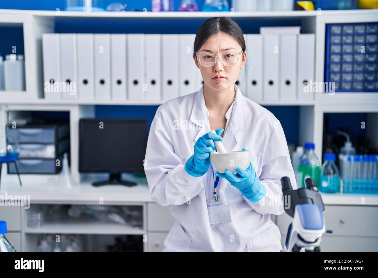 Chinese young woman working at scientist laboratory mixing depressed ...